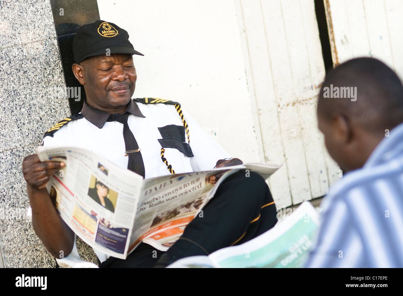 Security guard reading paper, Kisumu, Kenya Stock Photo - Alamy