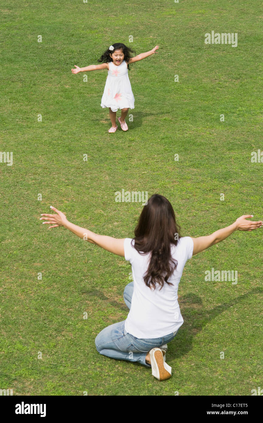 Girl running towards her mother in a park Stock Photo - Alamy