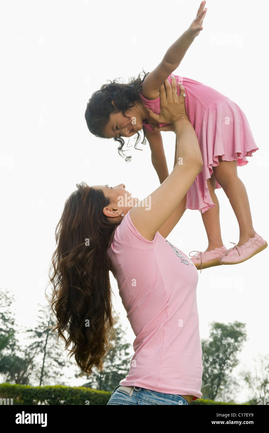Woman picking up her daughter Stock Photo - Alamy