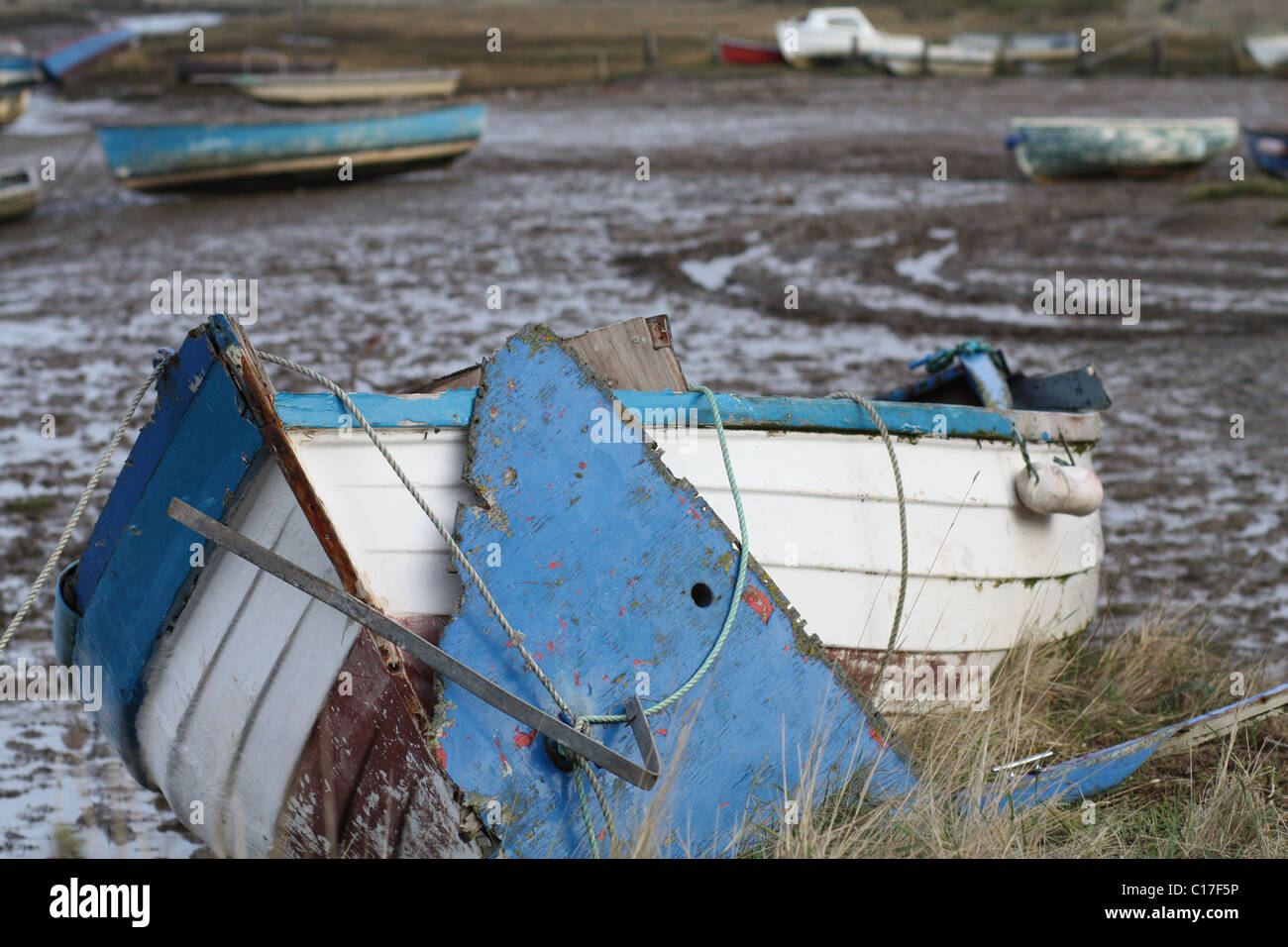 Small boat left on muddy estuary Stock Photo - Alamy