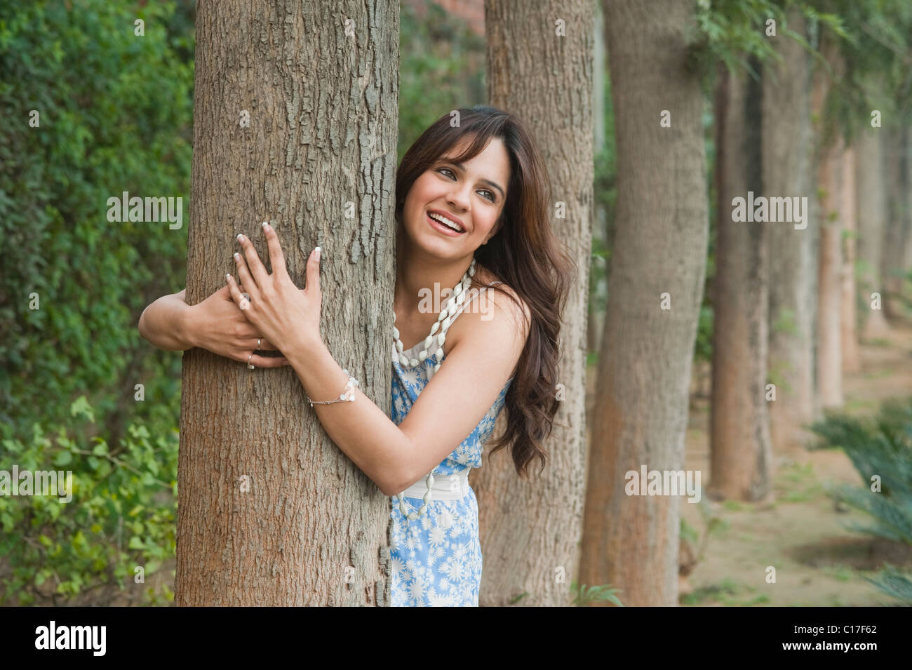 Woman hugging a tree and smiling Stock Photo - Alamy