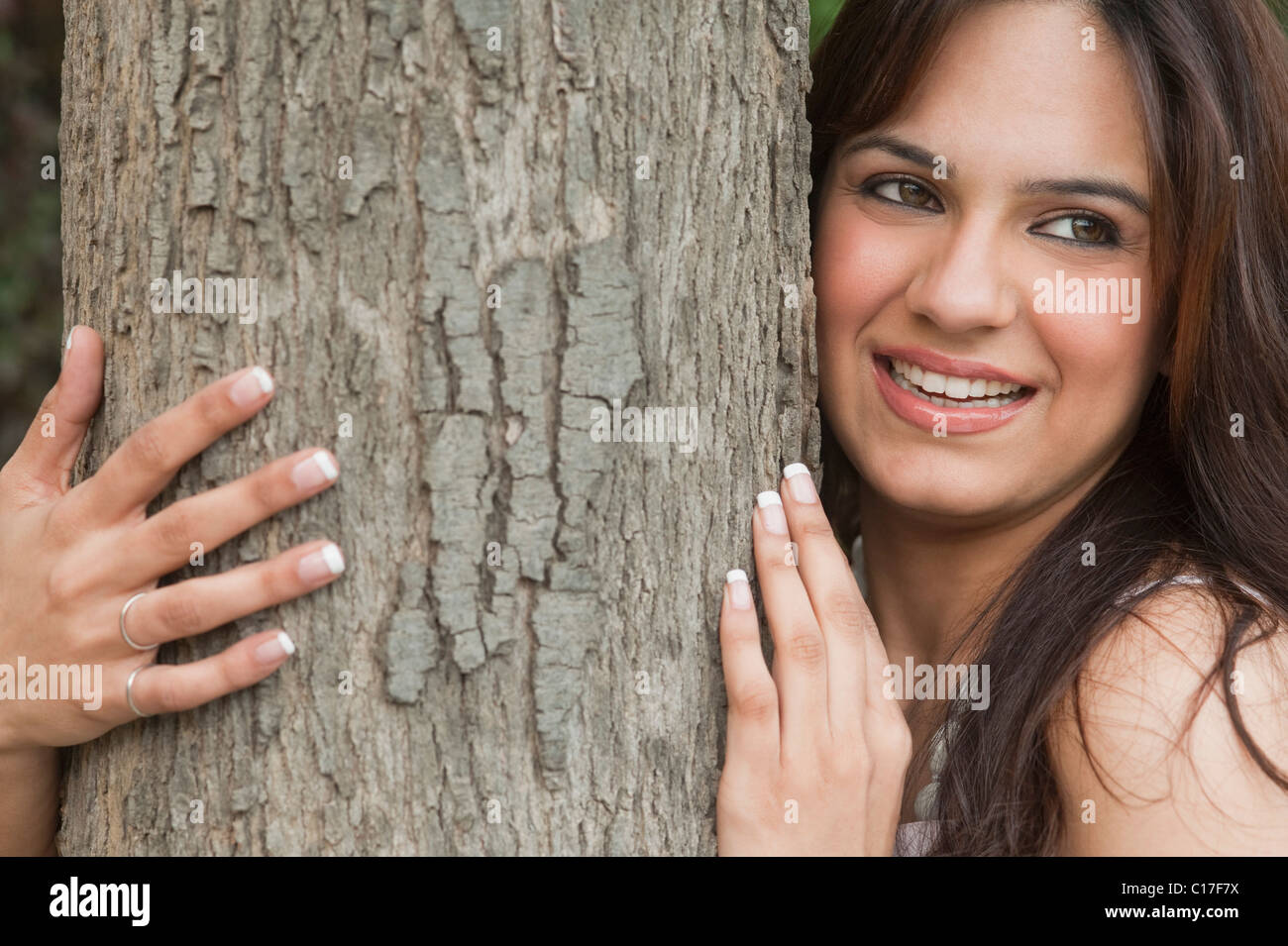 Woman hugging a tree and smiling Stock Photo - Alamy