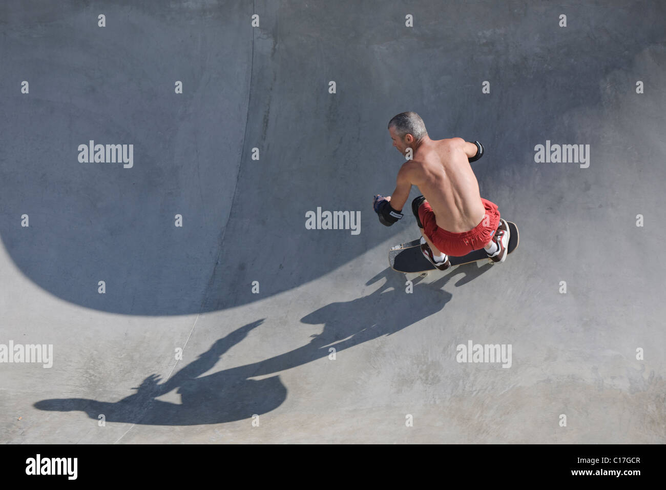 middle aged man skate boarding on ramp with shadow Stock Photo - Alamy