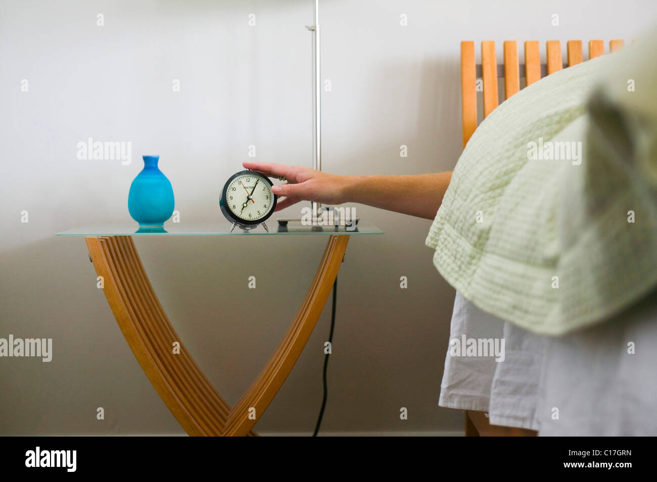 Woman turning off Alarm Clock Stock Photo - Alamy