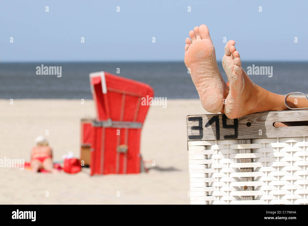 Feet resting on a roofed wicker beach chair near Wenningstedt, Sylt ...