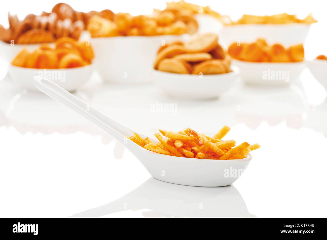 Potatoe sticks on spoon with a variety of spicy snacks Stock Photo - Alamy