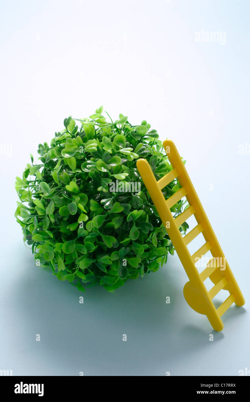 Miniature ladder propped up against a plastic plant Stock Photo - Alamy