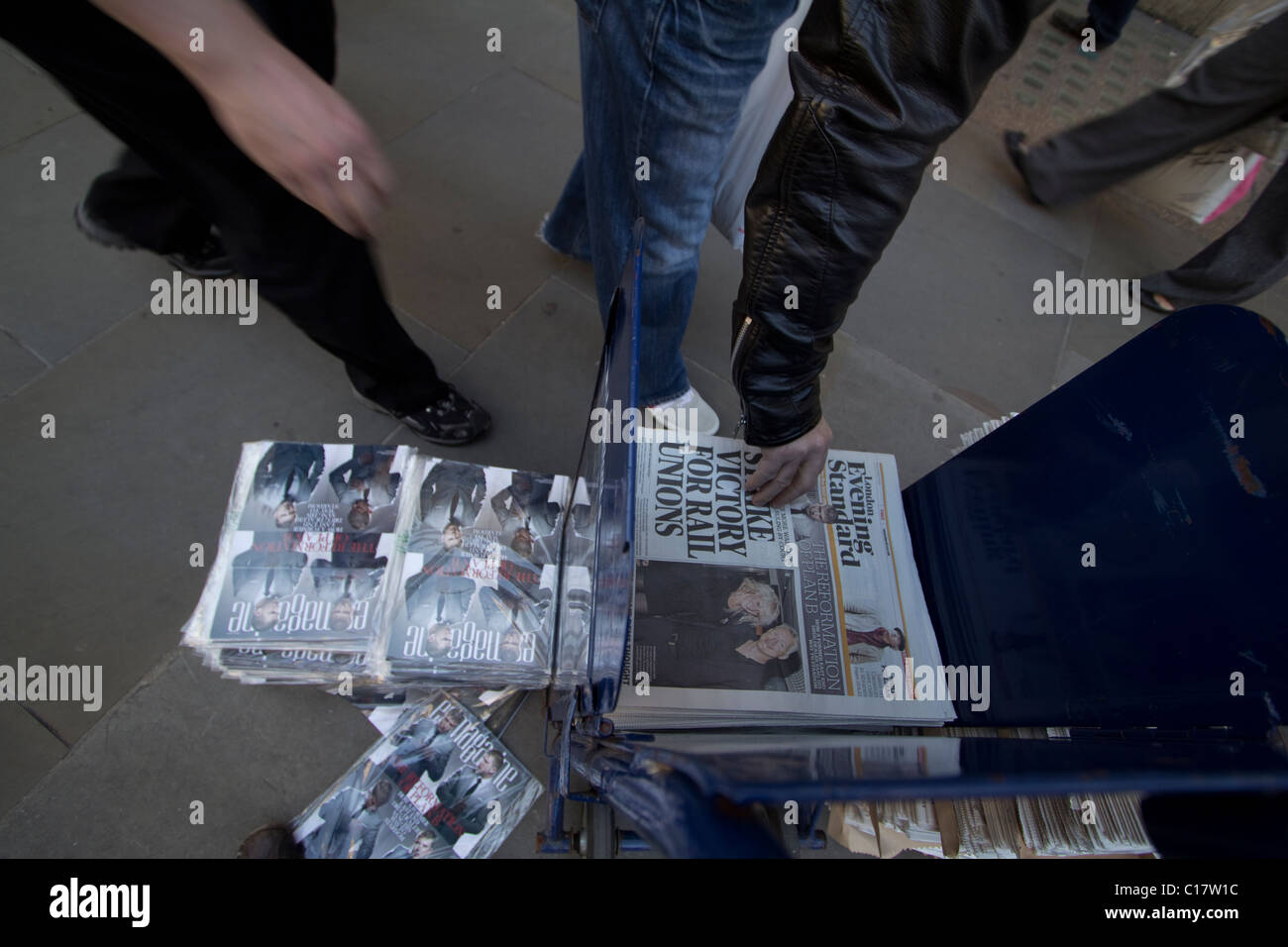 Commuters picking up copies of Evening Standard London's evening paper ...