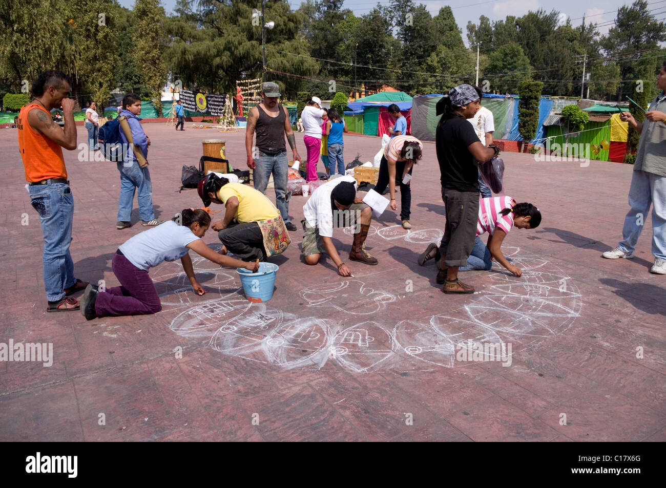 Aztec dance group drawing a figure with colored sand on the day of the ...
