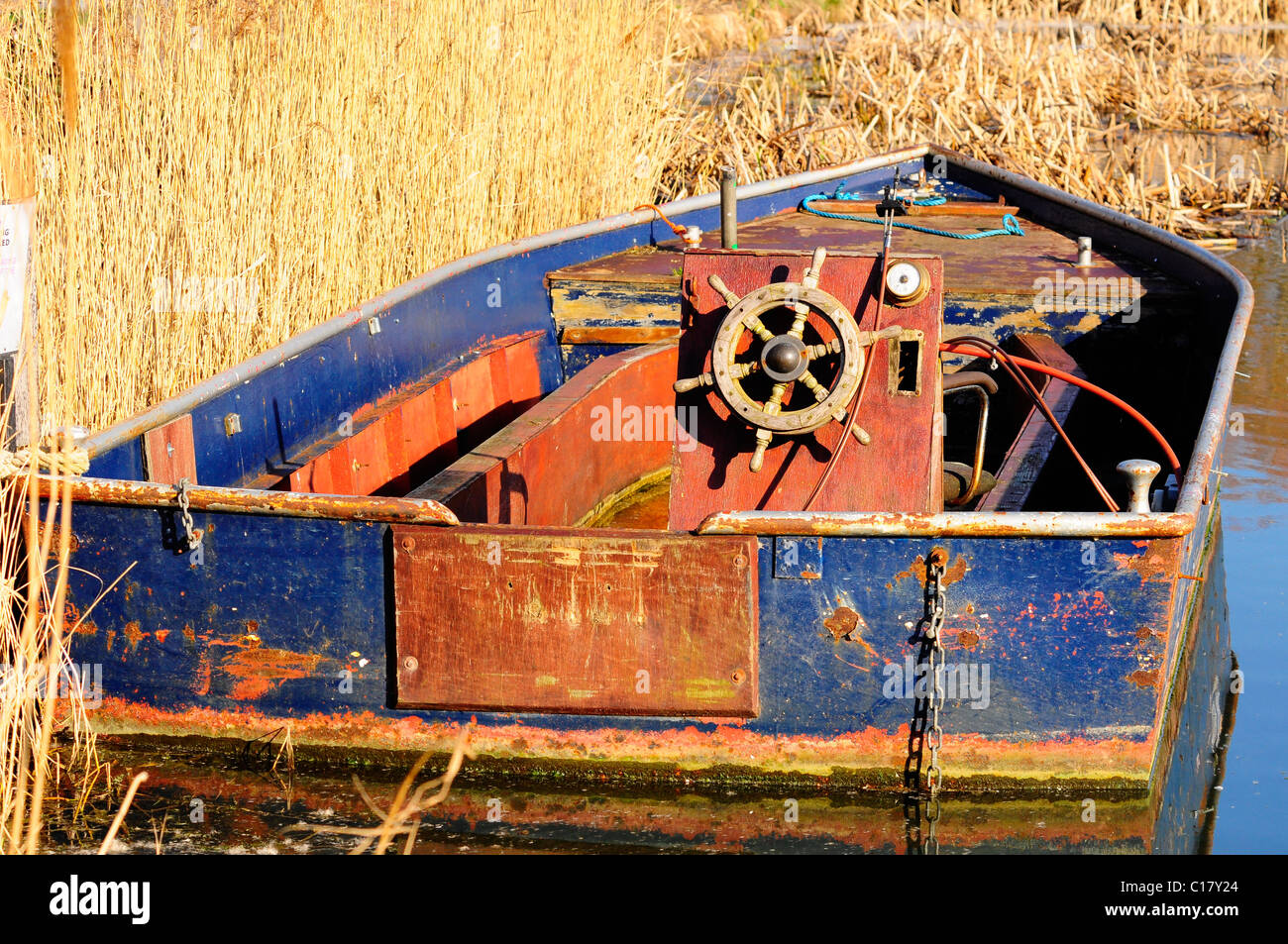 A decaying old boat floating at water edge Stock Photo - Alamy