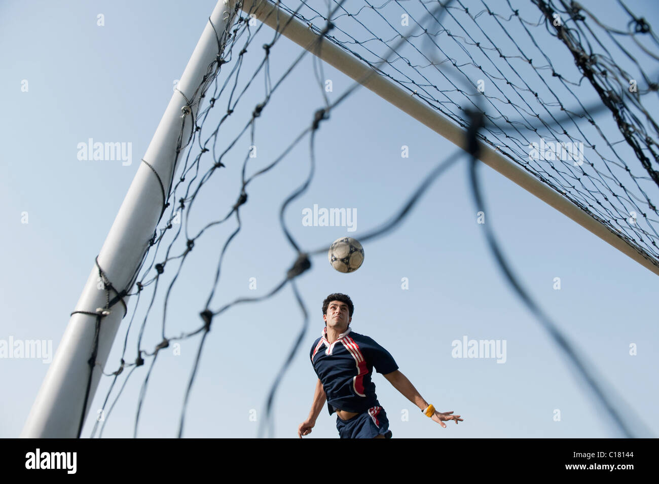 Soccer player heading a soccer ball in the net Stock Photo - Alamy