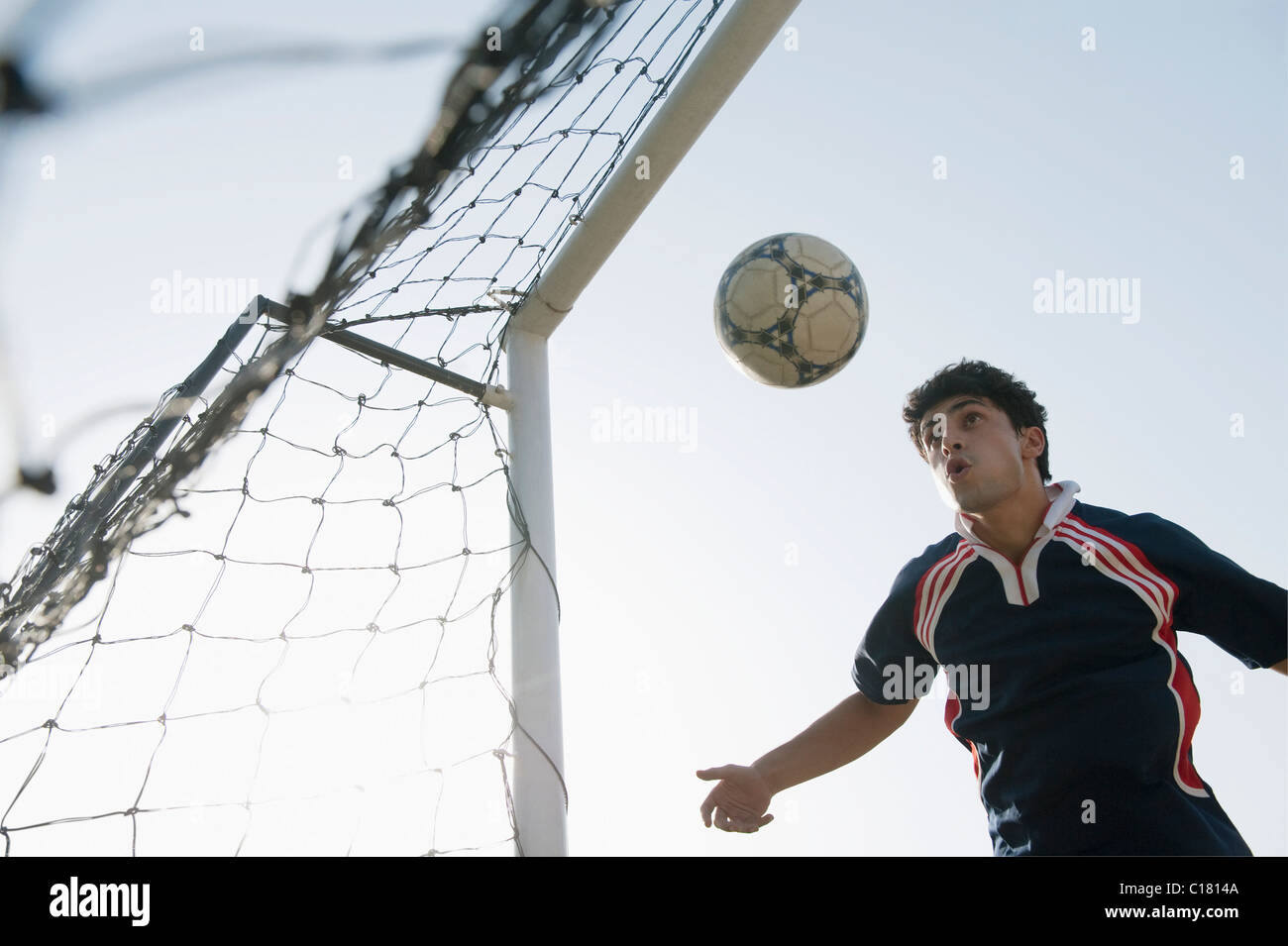 Soccer player heading a soccer ball in the net Stock Photo - Alamy