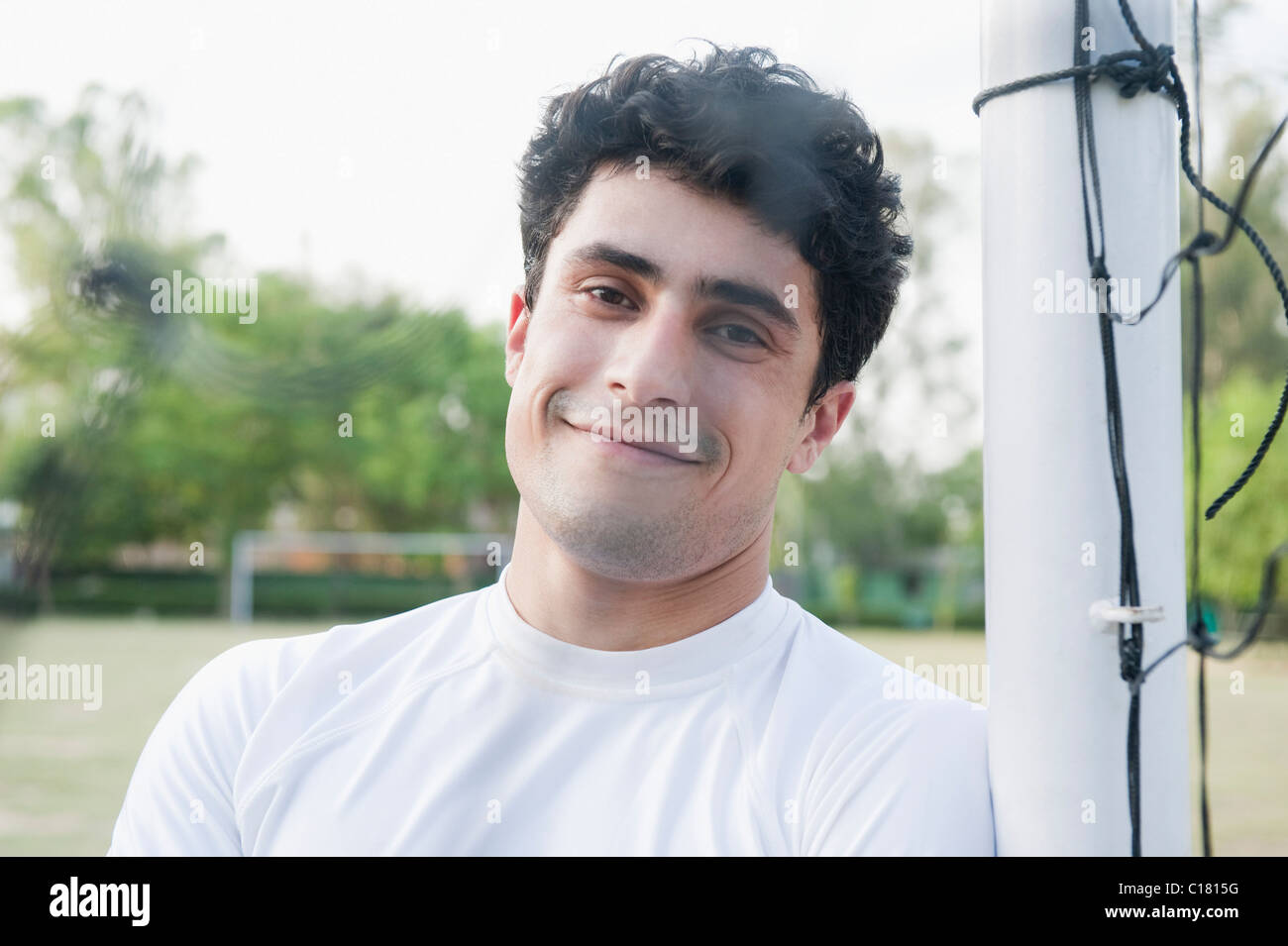 Goalie smiling at the goal post Stock Photo - Alamy