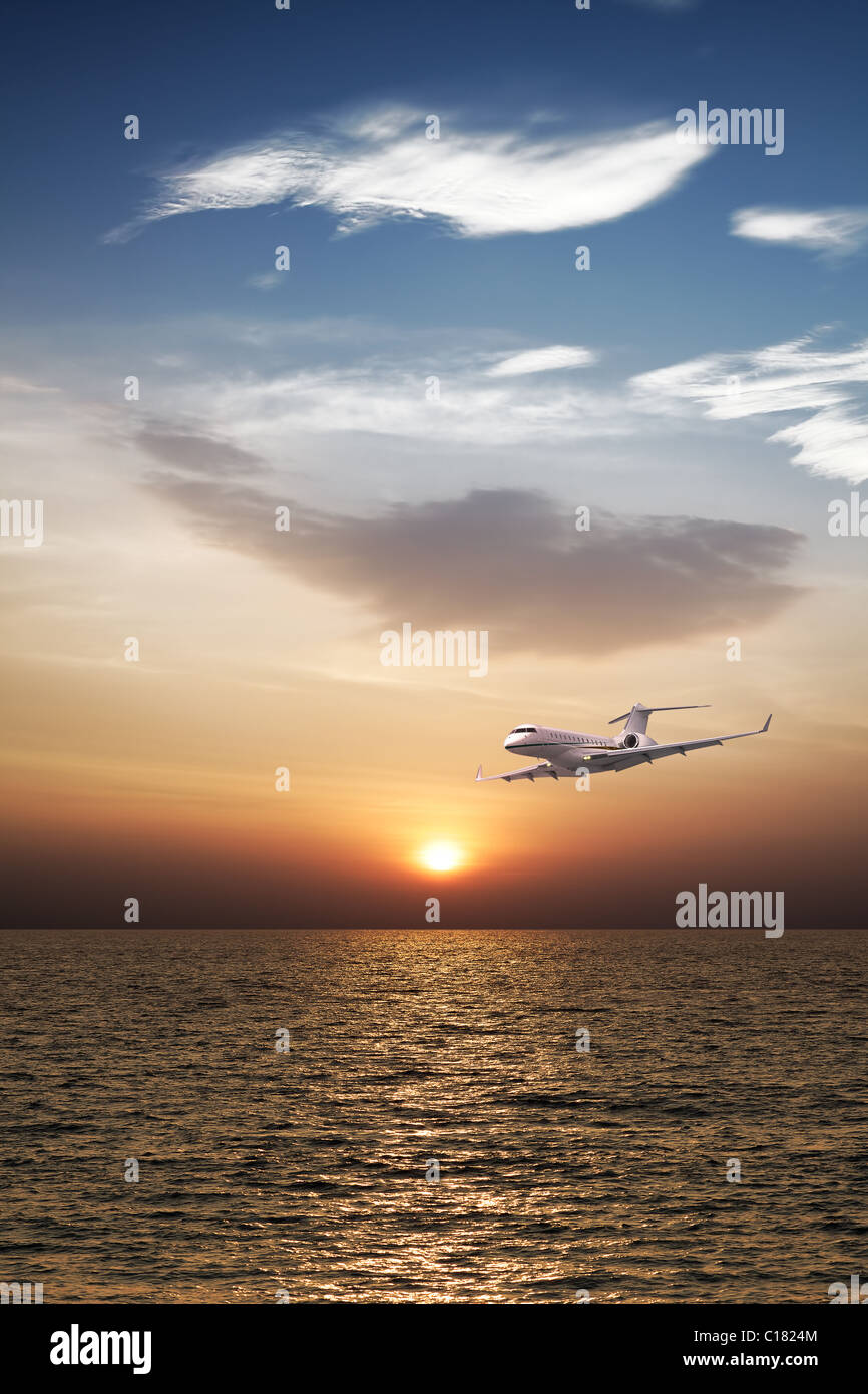 Jet plane over the sea at dusk Stock Photo - Alamy