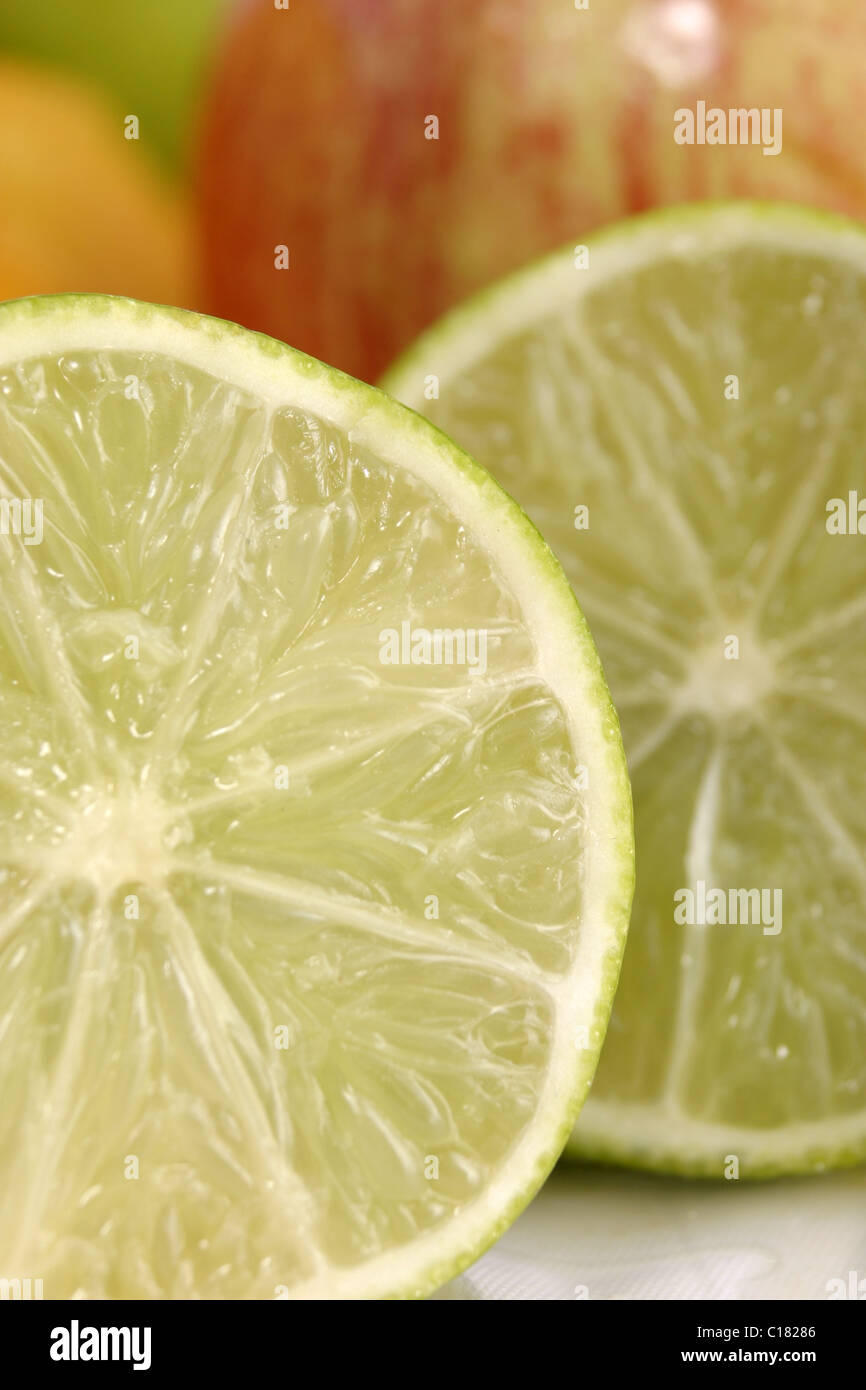 Extreme close-up view of two slices of lime and an apple and other ...