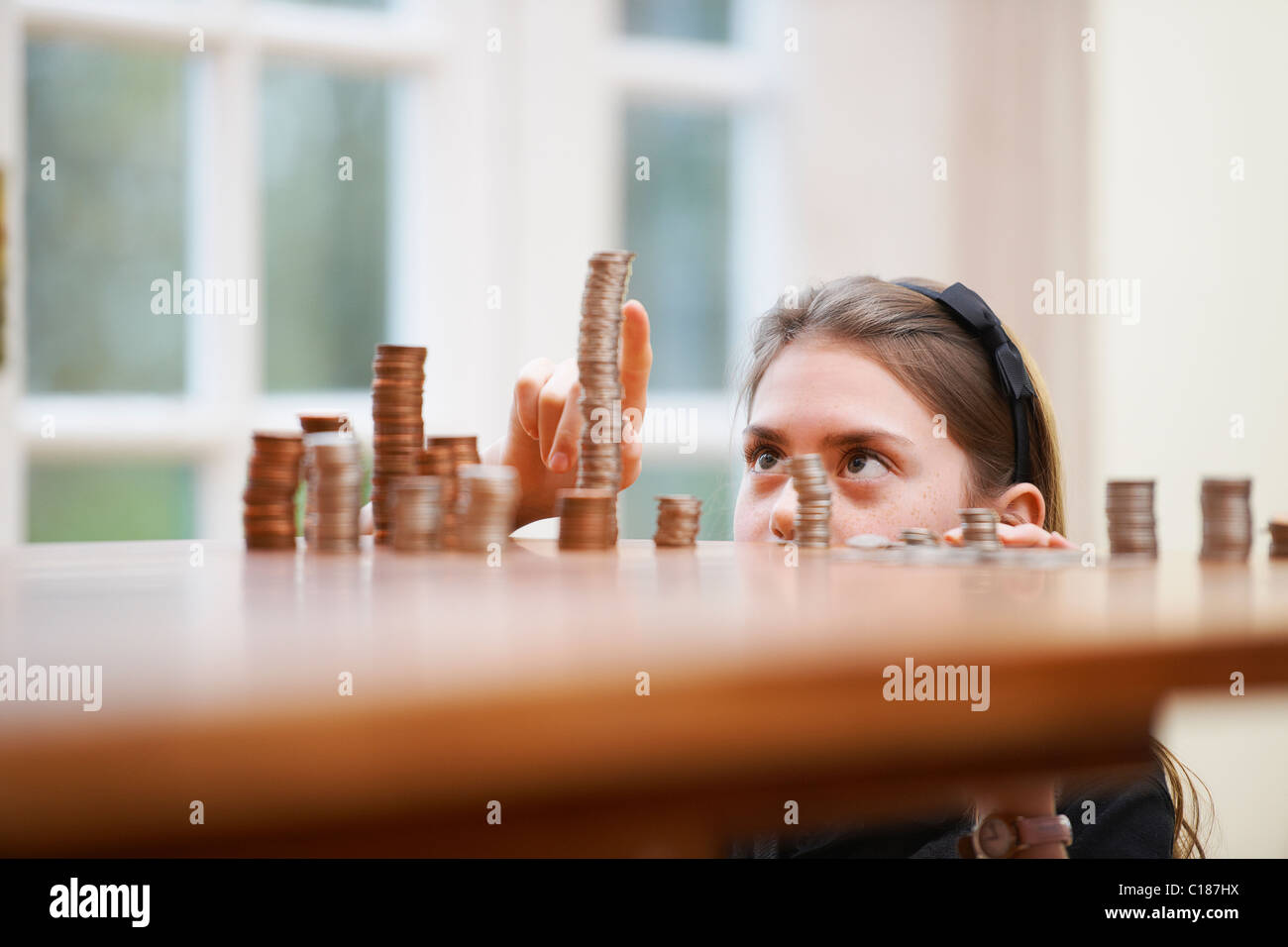 Girl counting piles of money Stock Photo - Alamy