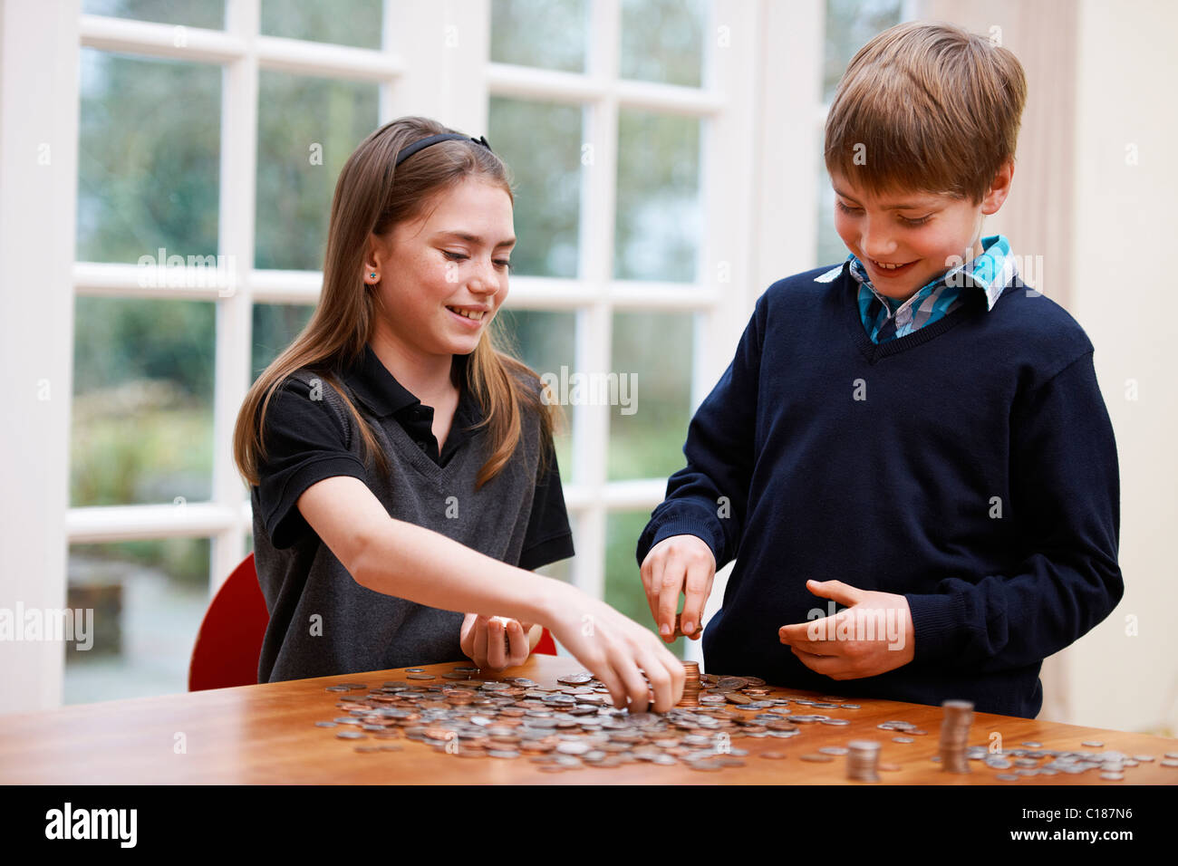 Children counting piles of coins Stock Photo - Alamy