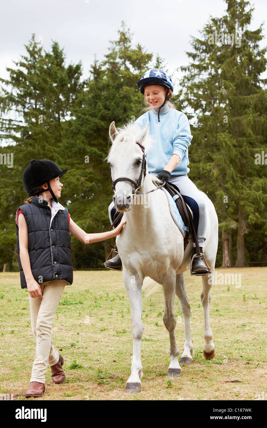 Girls riding a pony Stock Photo - Alamy