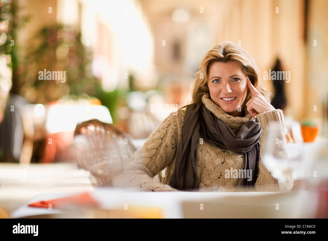 Woman sitting in restaurant Stock Photo - Alamy