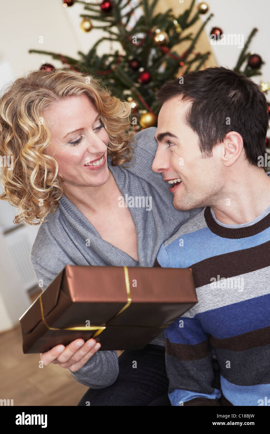 Woman presenting man a gift Stock Photo - Alamy