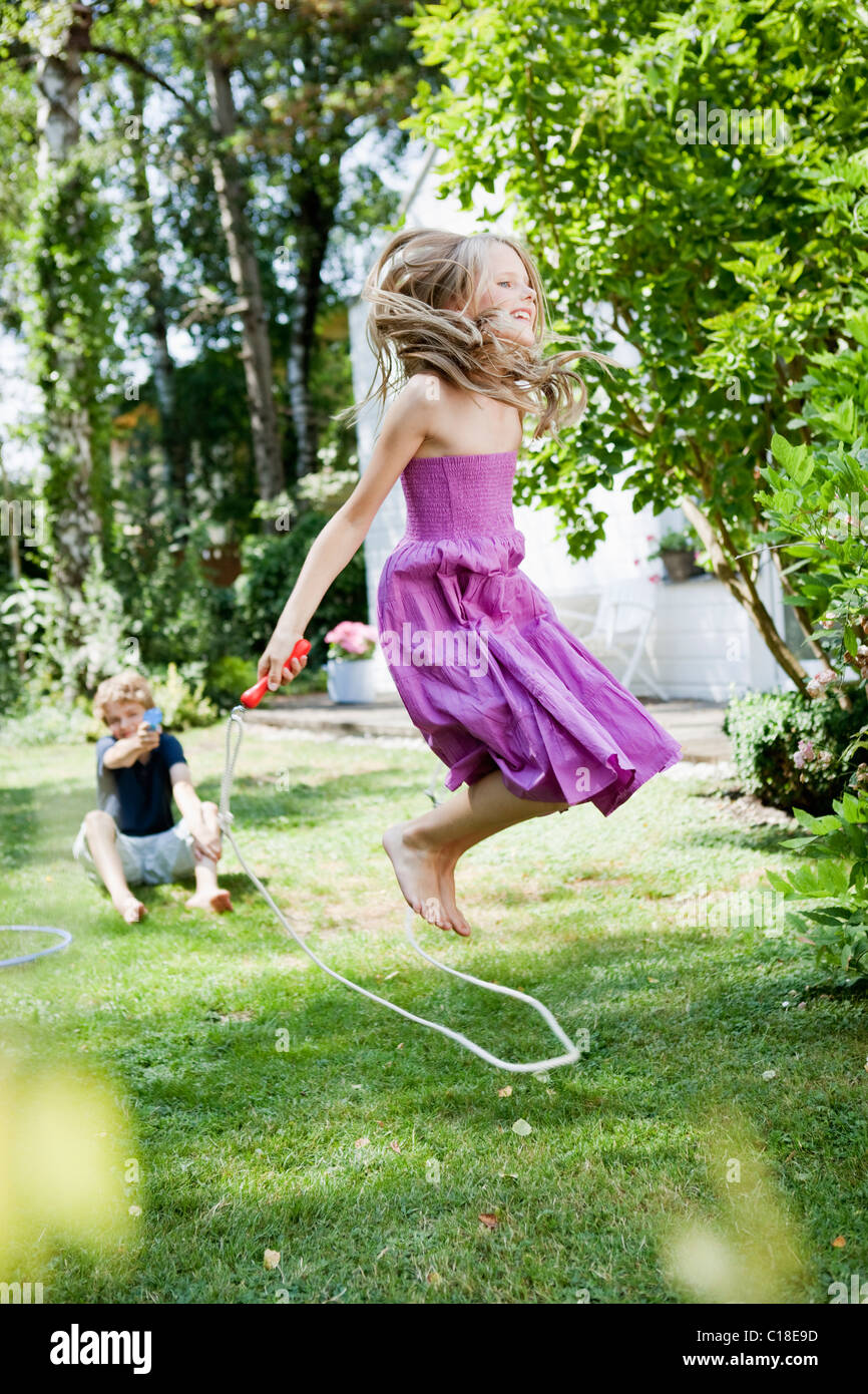 Girl jumping rope in garden Stock Photo - Alamy