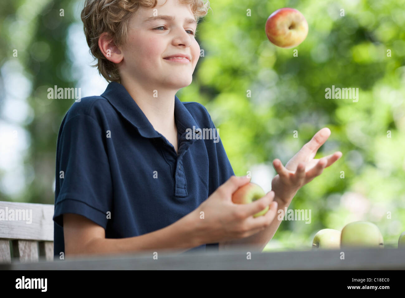 Boy juggling apples Stock Photo - Alamy