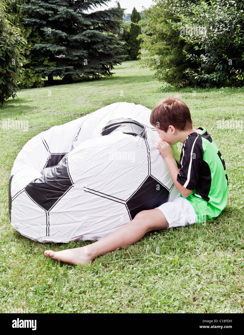 Boy inflating giant football Stock Photo - Alamy