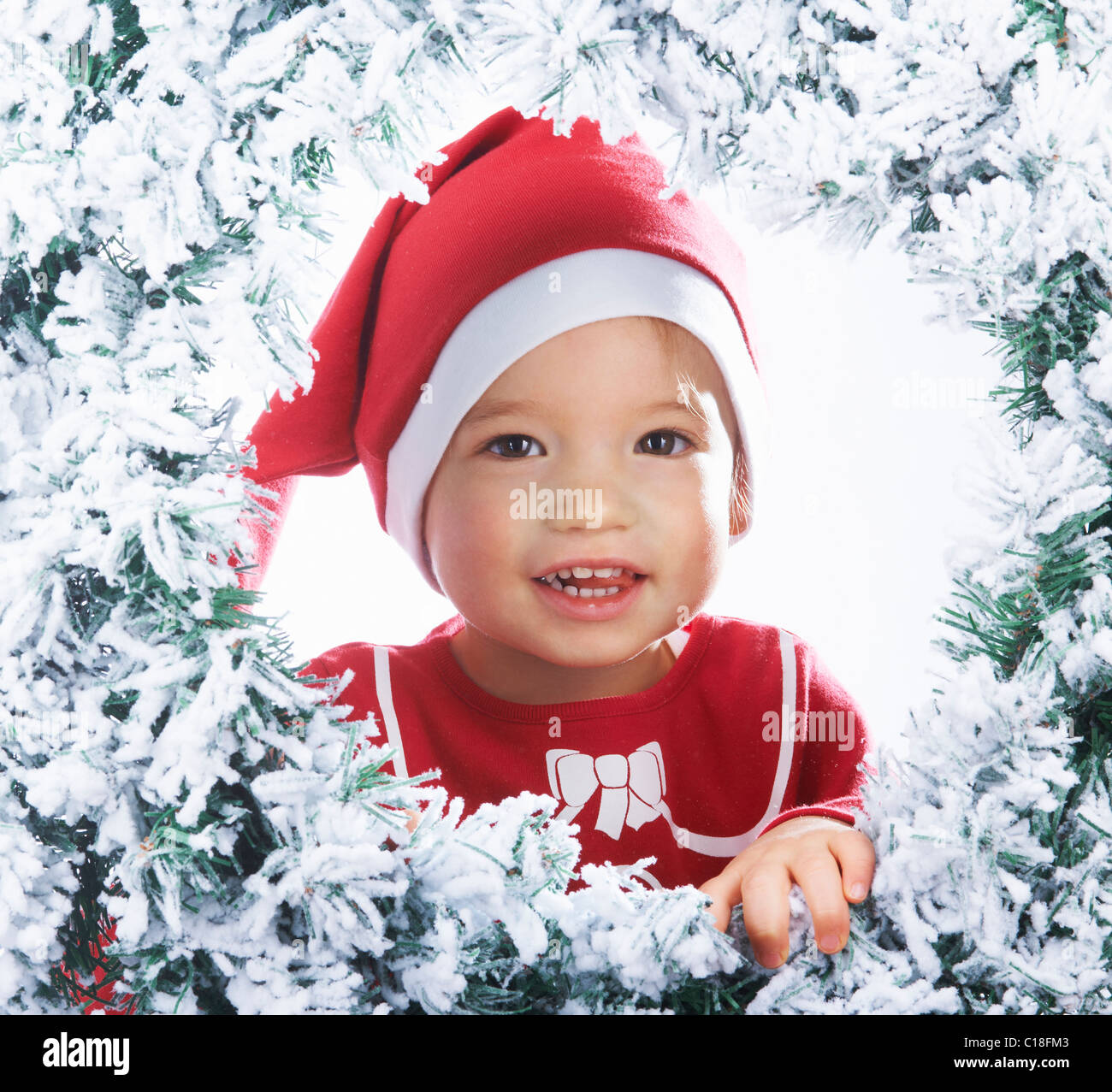 Baby girl looking through the snowy tree Stock Photo - Alamy