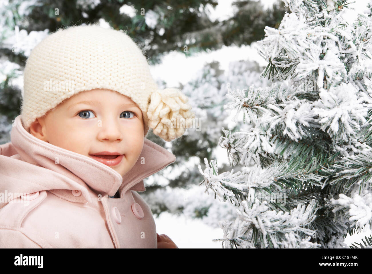 Baby girl beside snowy trees Stock Photo - Alamy