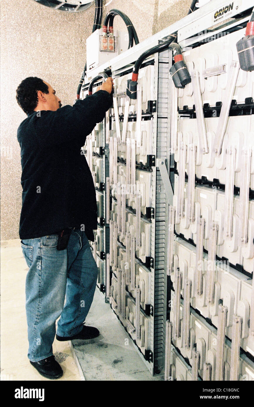 A It Technician Doing Routine Battery Backup Storage Maintenance In A Telecommunications 