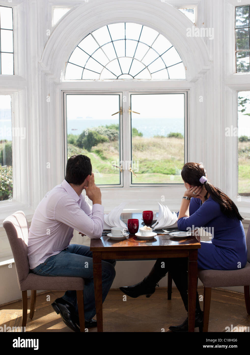 Couple looking out of the window Stock Photo - Alamy