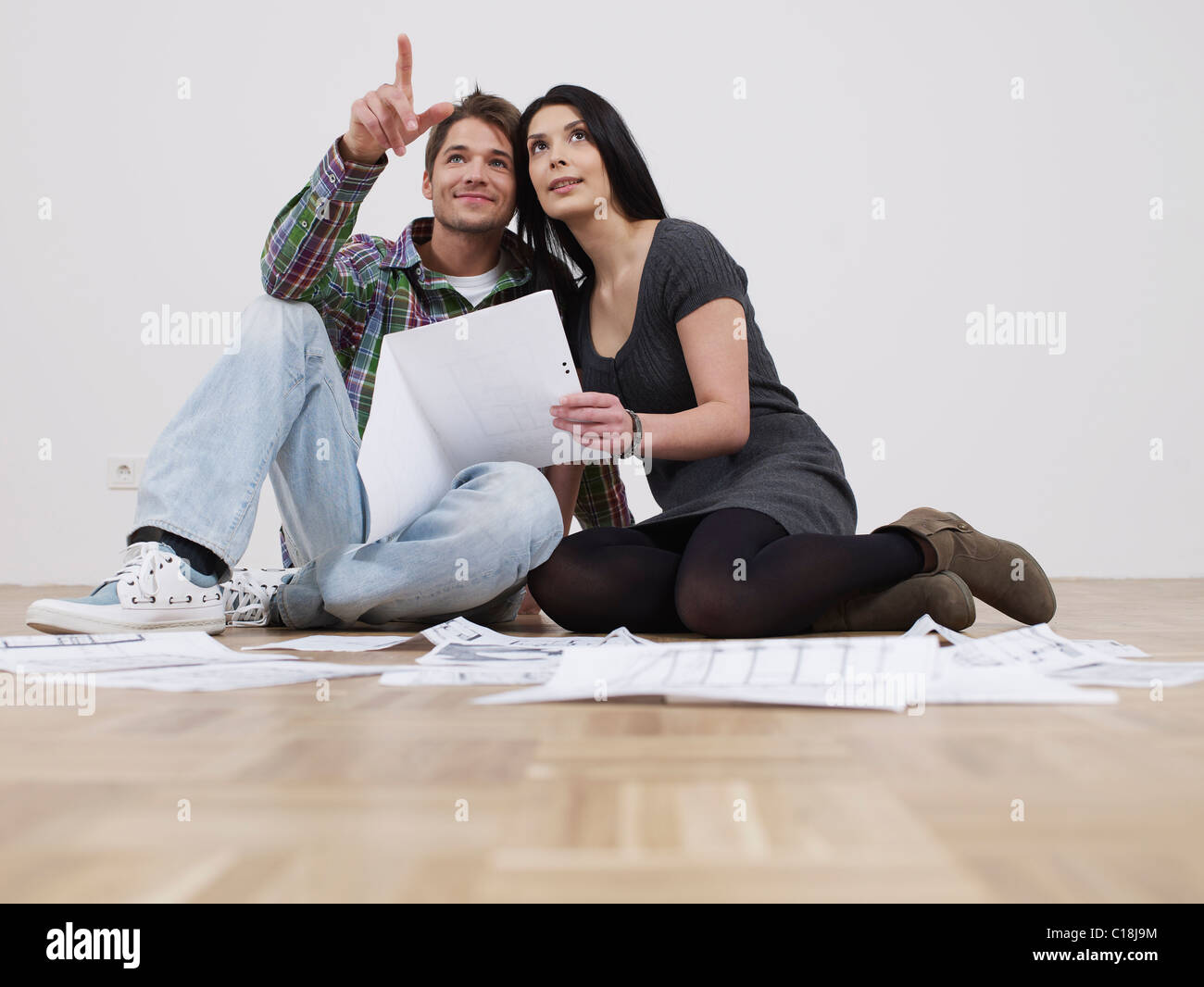 Couple sitting in empty flat Stock Photo - Alamy