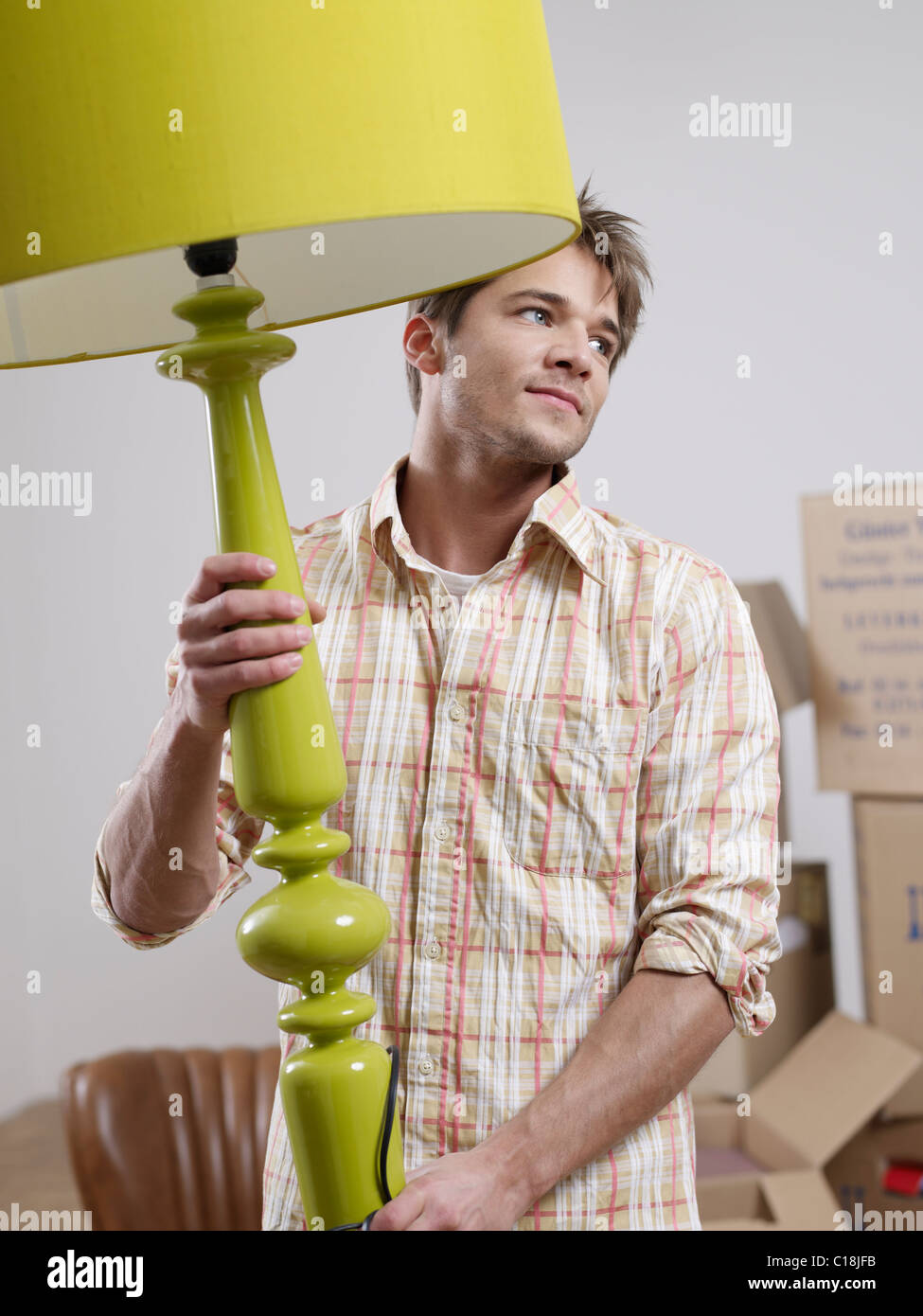 Young man carrying lamp Stock Photo - Alamy