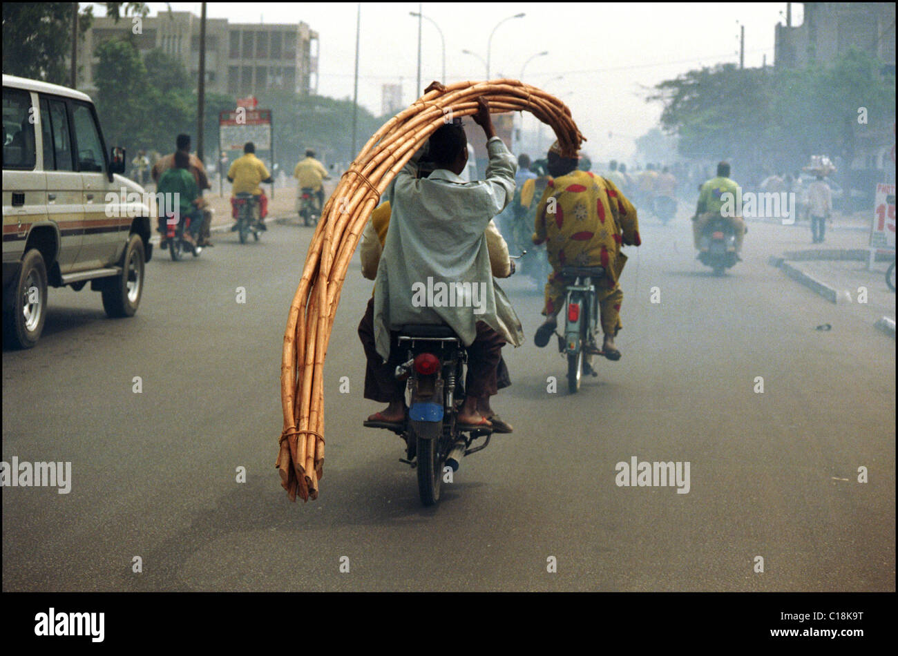 A boy carrying bamboo canes on a Zem. Benin Stock Photo - Alamy