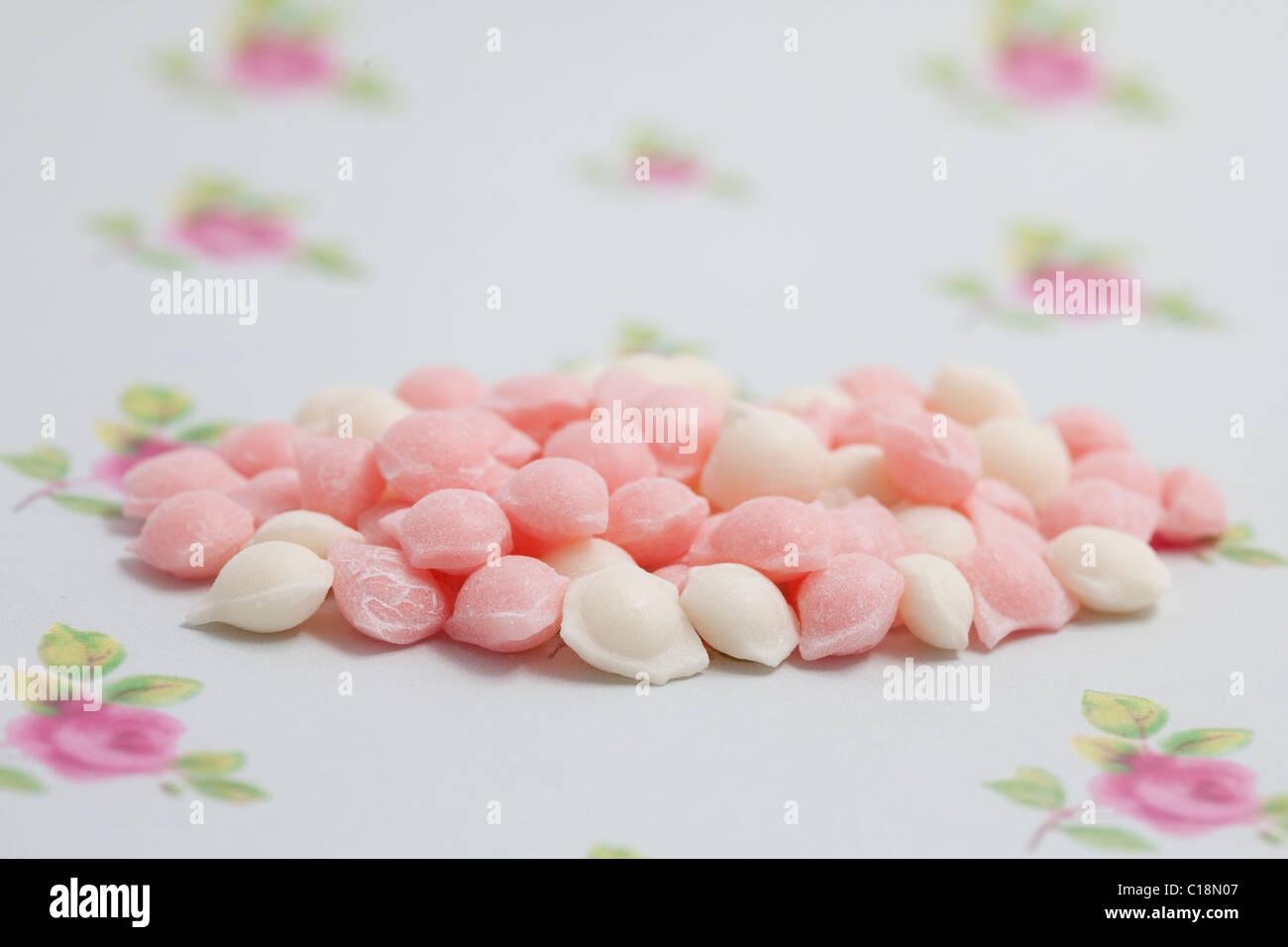 pink and white pips sweets and candy on a paper background photographed ...
