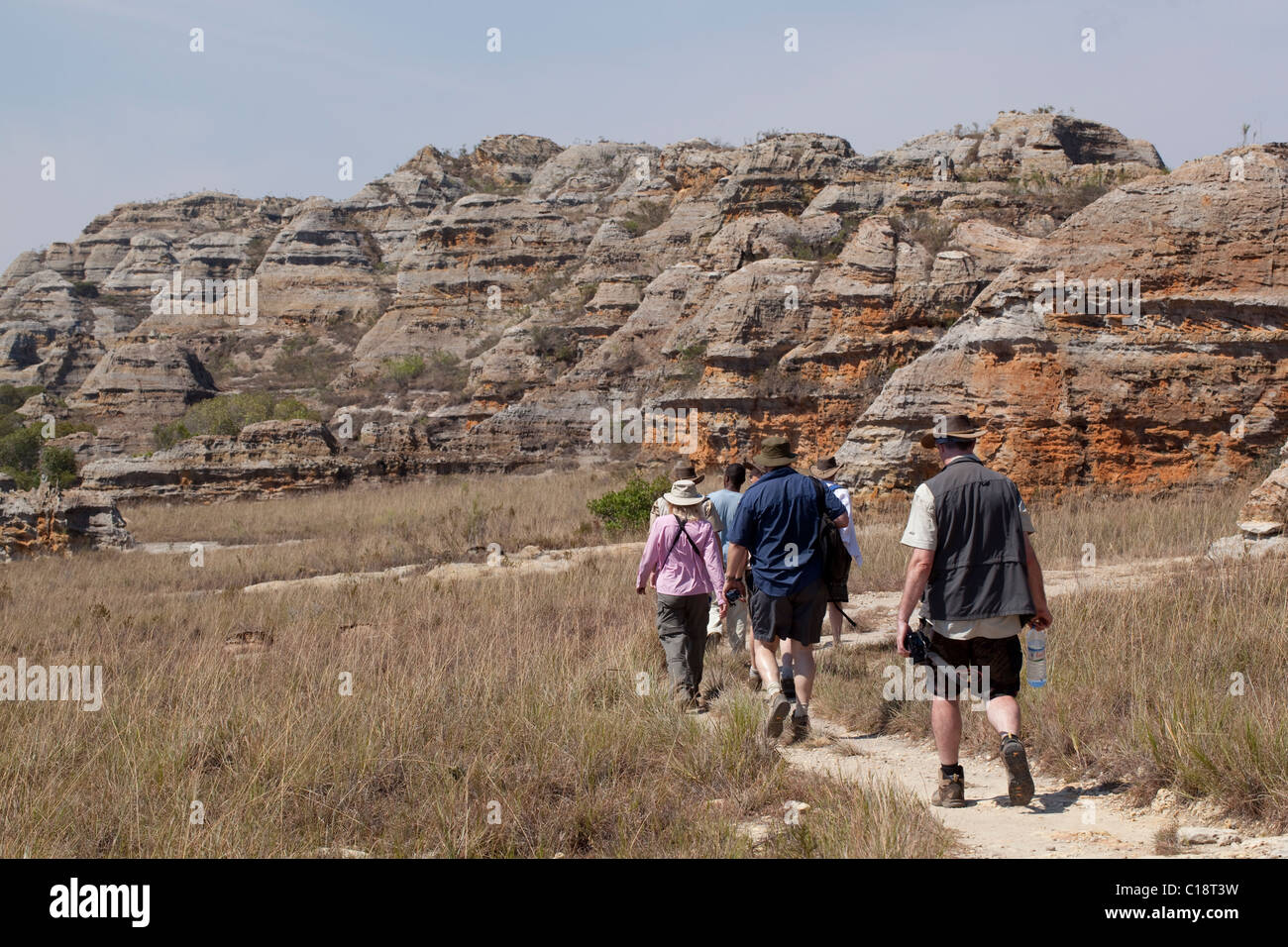 Tourists trekking through Isalo National Park, Madagascar, against a ...