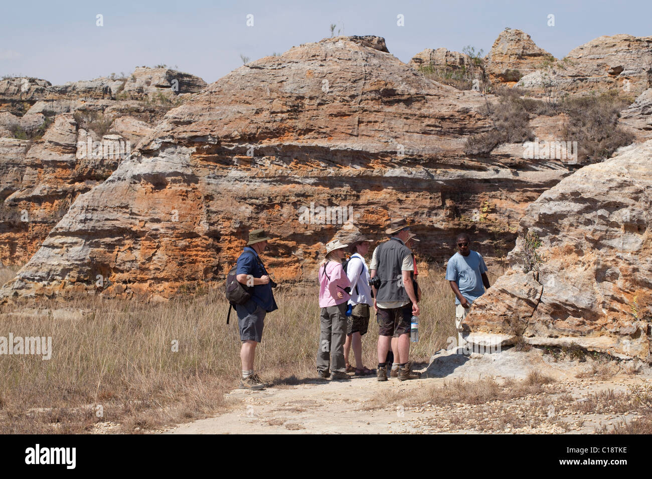 Tourists trekking through Isalo National Park, Madagascar, against a ...