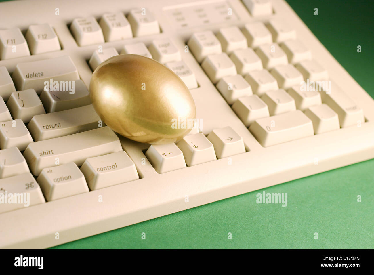 Golden egg on computer keyboard Stock Photo - Alamy