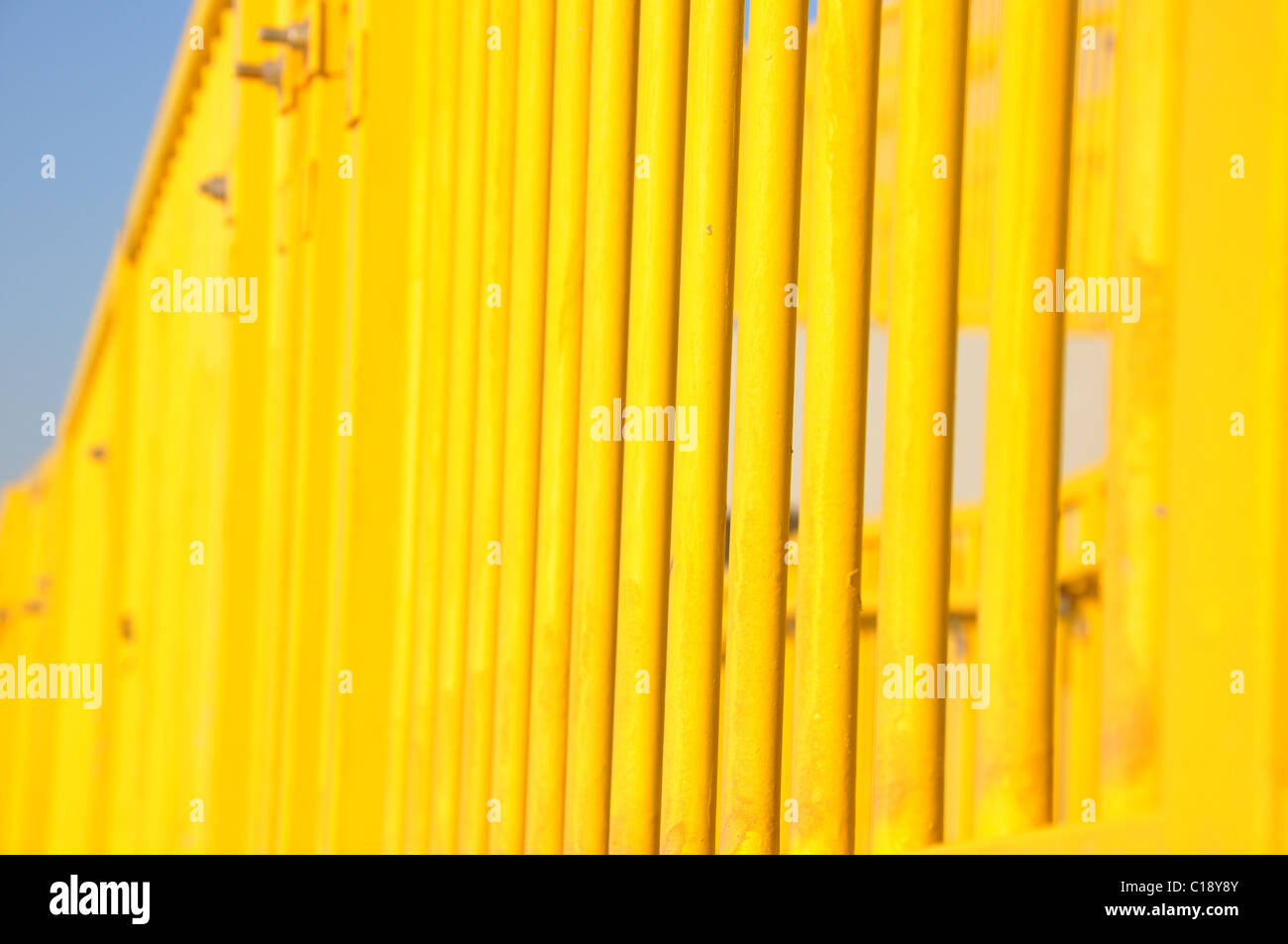 A pattern of vertical bright yellow stair railings Stock Photo - Alamy