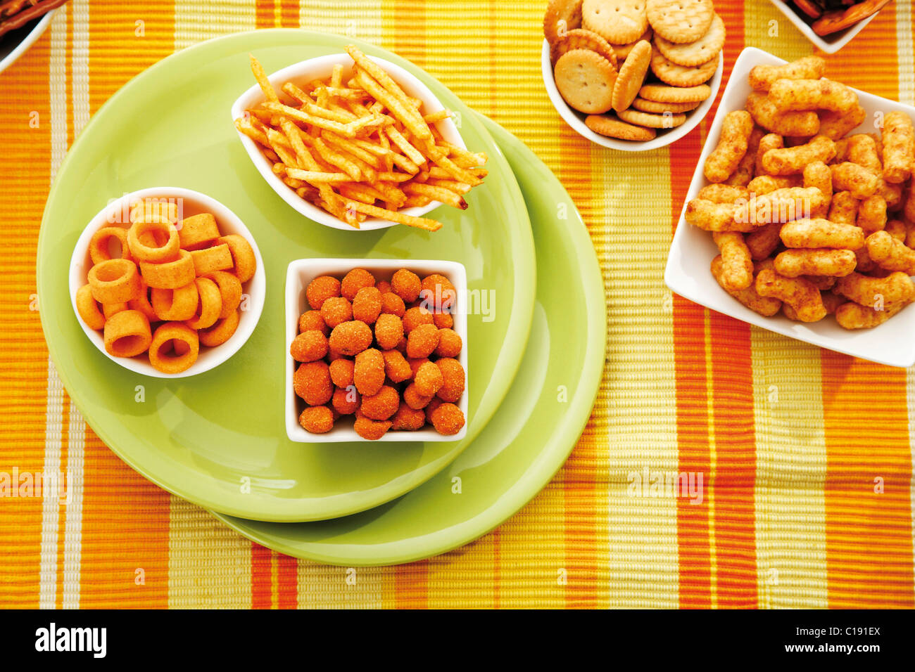 Various spiced snacks in bowls, crisps, peanut flips, potato sticks ...