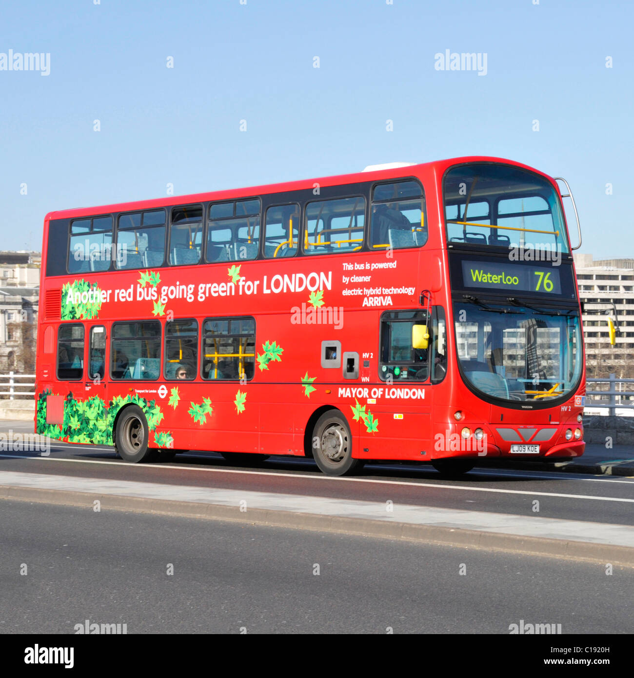 Side view of red double decker passenger bus going Green for public ...
