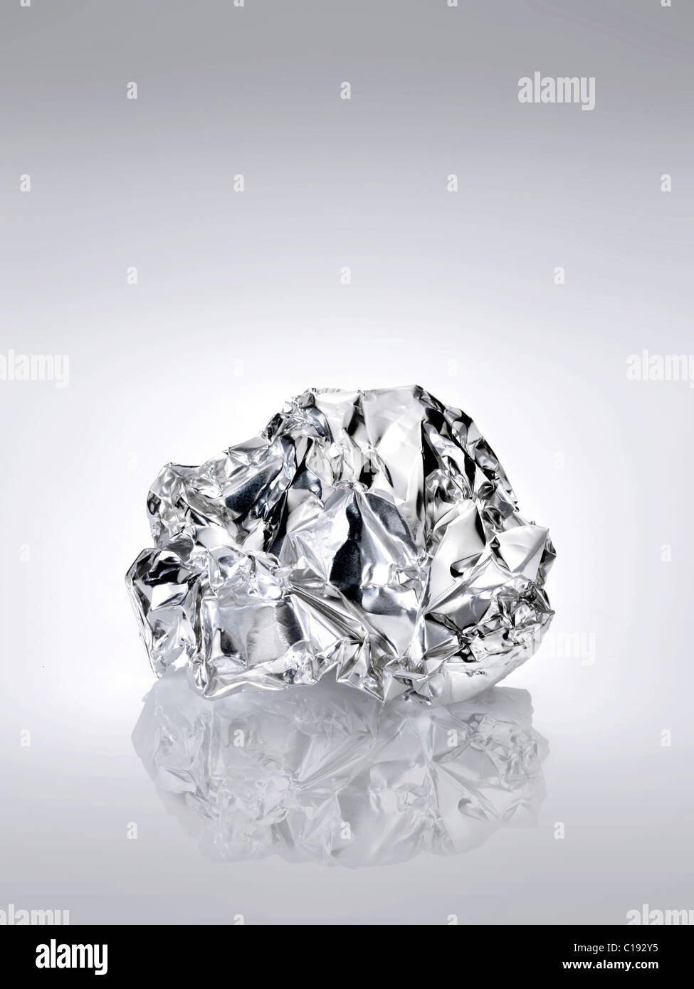 Crumpled up aluminium foil, reflection on white plexiglass Stock Photo ...