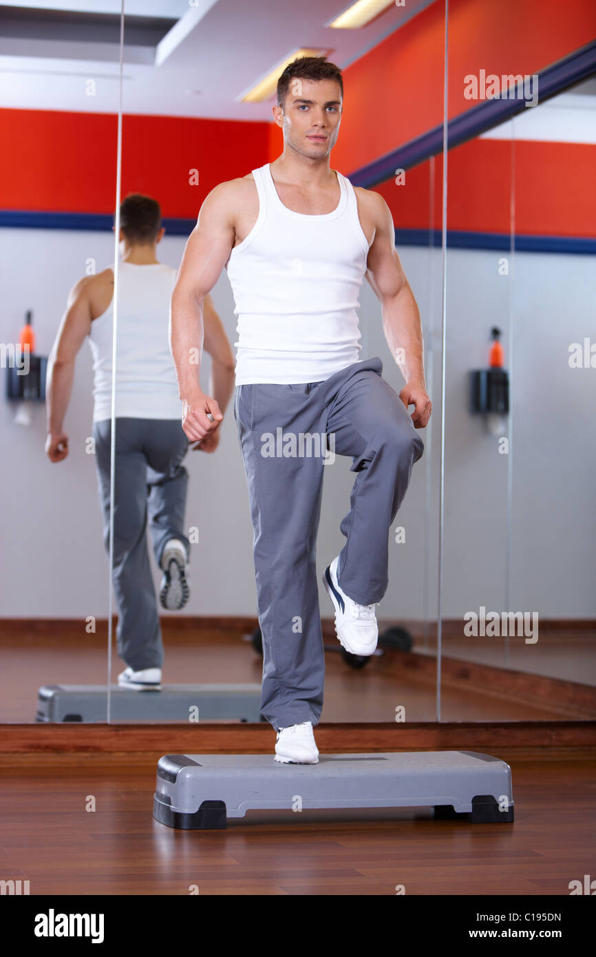 Handsome man at the gym doing exercises Stock Photo - Alamy