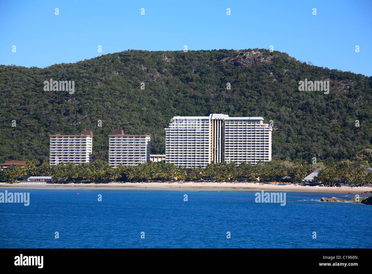 Hamilton Resort hotels on a tropical coastline with lush green hills ...