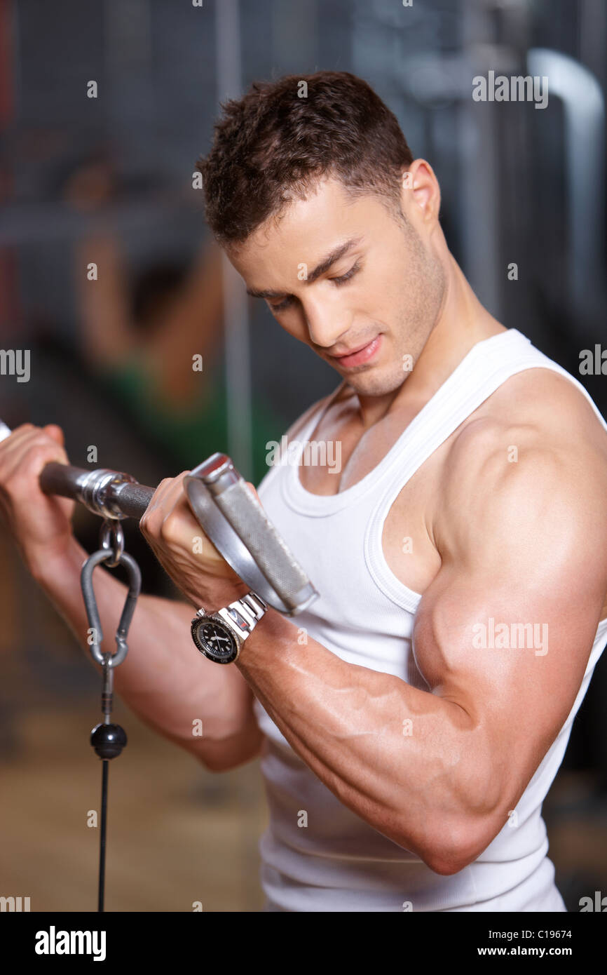 Handsome man at the gym doing exercises Stock Photo - Alamy