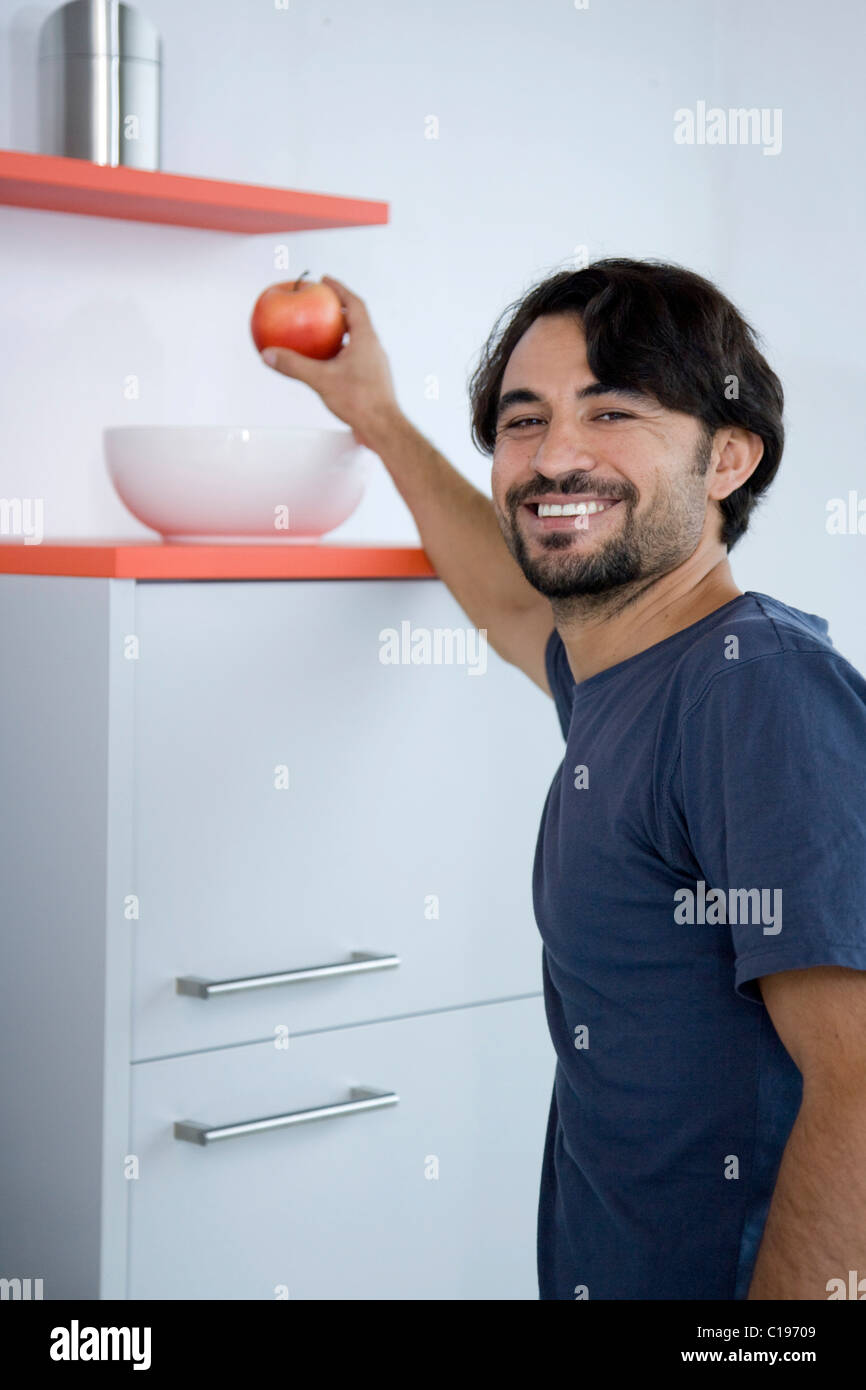 Man taking an apple out of a bowl Stock Photo - Alamy