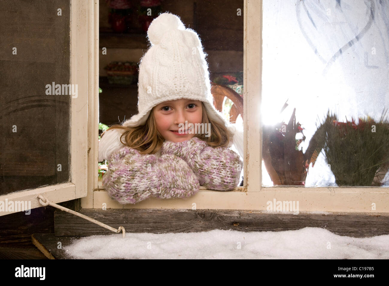 Girl looking out of the window of a cottage Stock Photo - Alamy