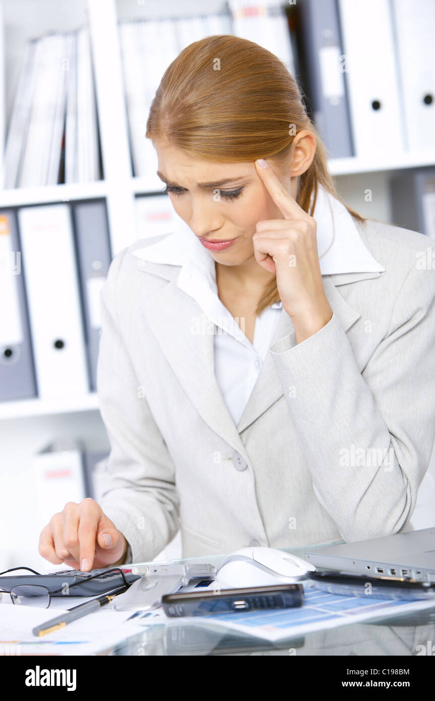 Beautiful business woman using calculator and thinking Stock Photo - Alamy