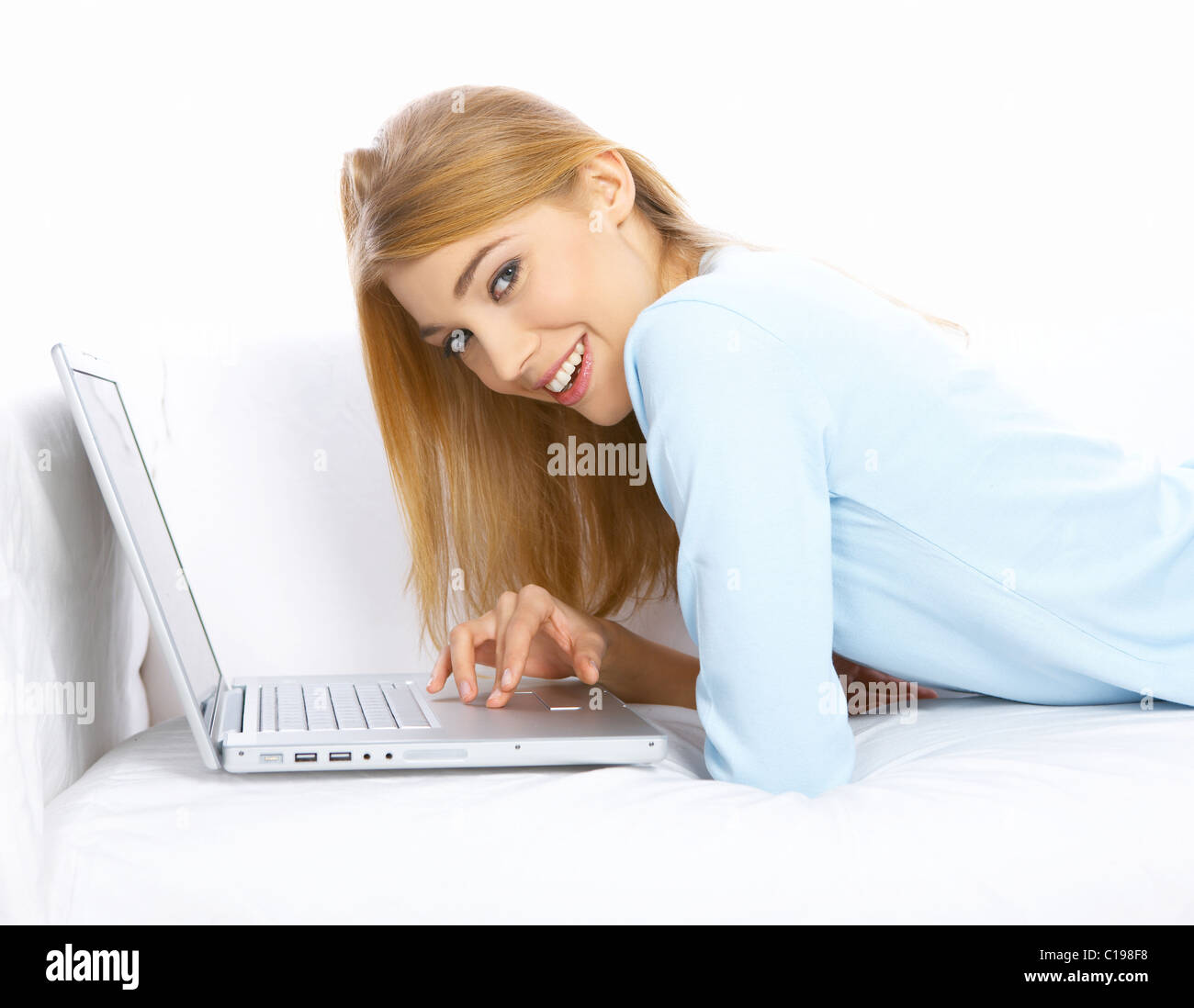 Young woman sitting on couch and working on laptop Stock Photo - Alamy