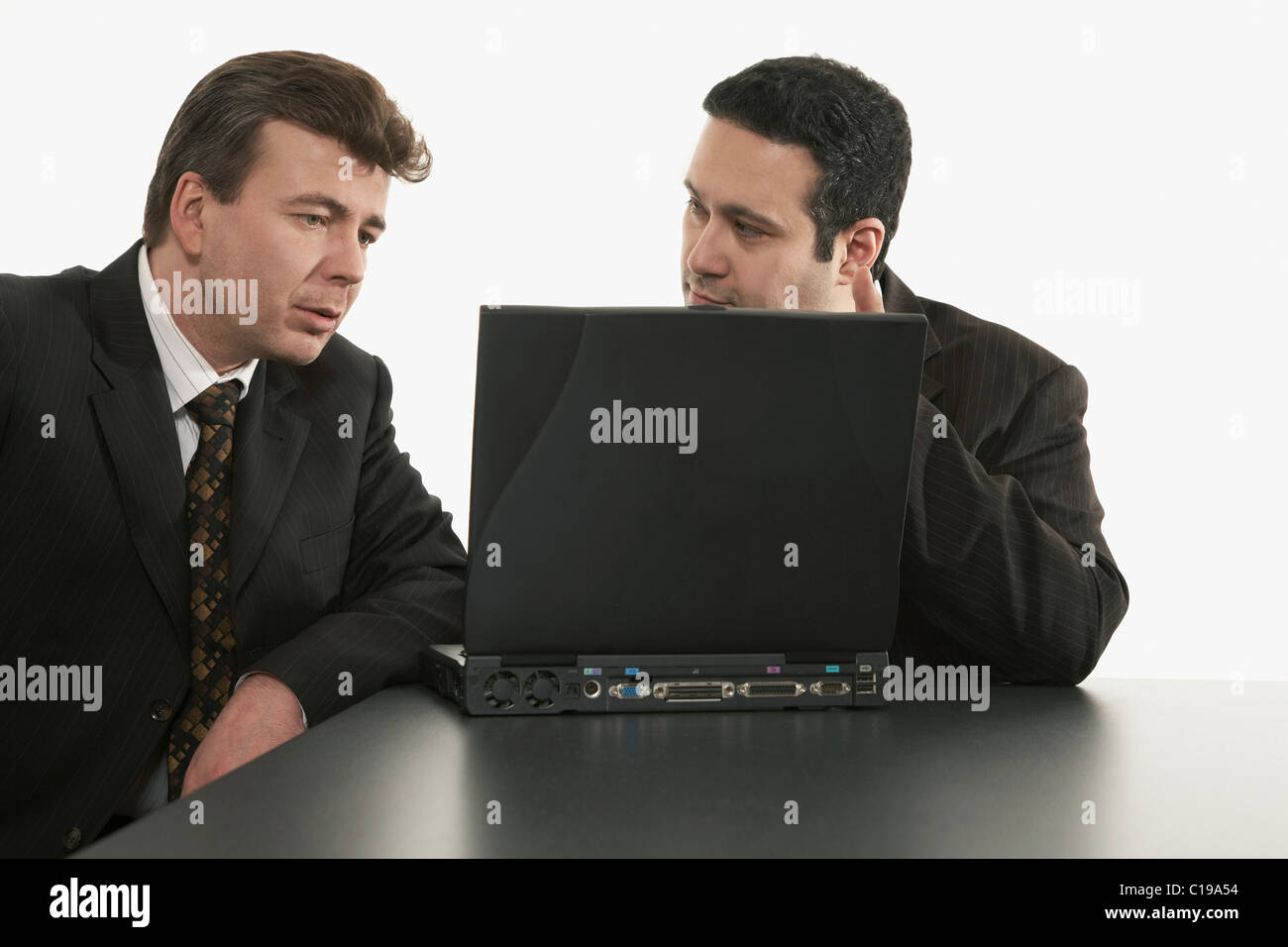 Two businessmen sitting behind a laptop Stock Photo - Alamy